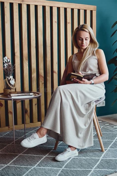 Young Woman Making Notes In Notebook Sitting At Workplace At Home