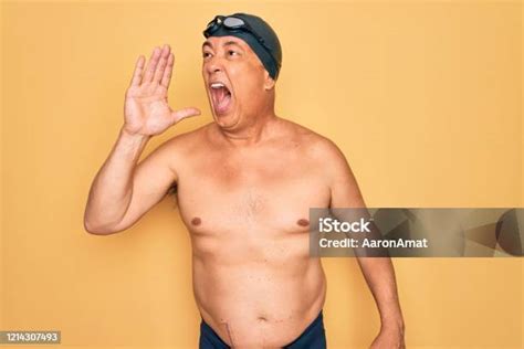 수영복 모자 고글을 입은 중년 선배 회색 머리 수영 선수는 입에 손을 대고 큰 소리로 외치고 비명을 지르고 있습니다 통신 개념입니다 감정에 대한 스톡 사진 및 기타 이미지