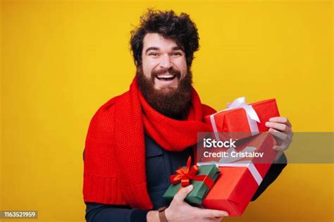 빨간 스카프에 잘 생긴 수염 남자 선물 상자를 들고 판매 개념 선물을 즐기는 고립 된 노란색 배경 공예에 대한 스톡 사진 및 기타 이미지 Istock