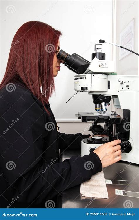 Young Female Scientist Analyzing A Patient Sample Under A Fluorescence