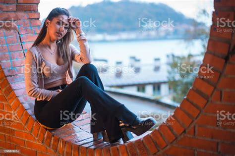 백인 갈색 머리 모델은 아름다운 포니 테일과 분홍색 스웨터와 배경에 도시와 앉아 스트리트 스타일 패션 25 29세에 대한 스톡 사진 및 기타 이미지 Istock