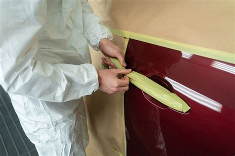 마스킹 테이프와 종이로 칠하기 전에 차체를 마스킹한 자동차 화가의 손을 클로즈업한 모습 25 29세에 대한 스톡 사진 및 기타