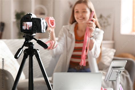 Female Sexologist With Whip And Handcuffs On Screen Of Camera At Home Closeup Stock Photo