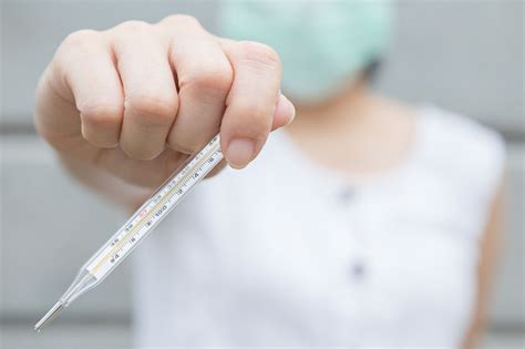 아시아 여성의 선택적 초점은 마스크를 착용하고 흐린 배경에 온도계를 들고 감기와 독감에 대한 스톡 사진 및 기타 이미지 감기와 독감 건강관리와 의술 규모 Istock