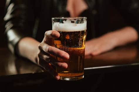 Woman With Big Breasts Holds A Glass Of Beer Lager With Foam In Her