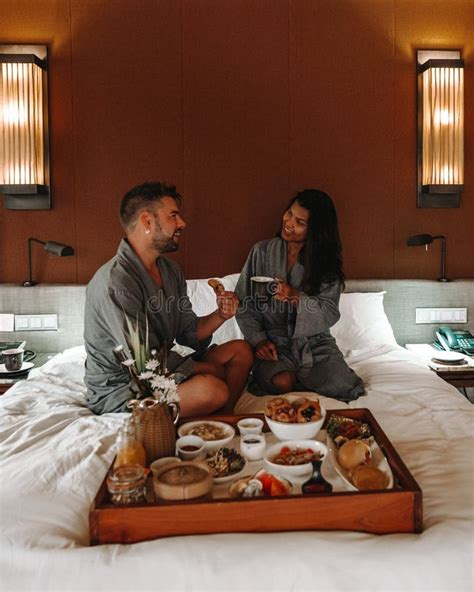 Couple Having Breakfast In Bed European Man And Asian Woman In Bed