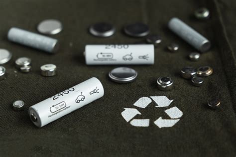 짙은 녹색 배경에 알카라인 배터리가 있는 플랫 누워 있습니다 화학 폐기물 재활용 환경 및 생태 절약 개념 유해 전자 폐기물