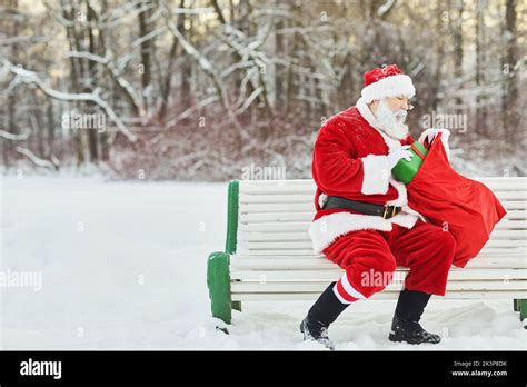 Side View Portrait Of Traditional Santa Claus Holding Bag With Presents