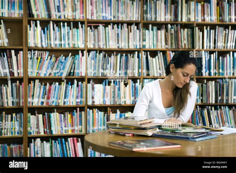 Woman Reading Book At Table In Library Stock Photo Alamy