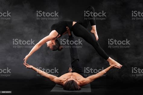 Acroyoga입니다 젊은 커플 함께 Acro 요가 스튜디오에 매트에 연습 커플의 요가 파트너의 요가 흑인과 백인 사진입니다