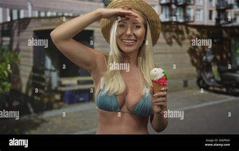 Woman Shading Eyes With Hand Holds Icecream Cone Wearing Straw Hat And