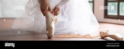 Ballerina In Ballet Shoes Asian GirlÂ Tying Ribbons Of Toe Shoes
