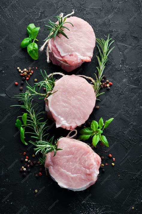 Premium Photo Raw Meat Medallions With Rosemary And Spices On A Black
