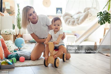 엄마와 작은 딸은 놀이방에서 시간을 보낸다 나무 스쿠터에 어린 소녀 모성 간호 사랑 개념 2명에 대한 스톡 사진 및 기타 이미지 Istock