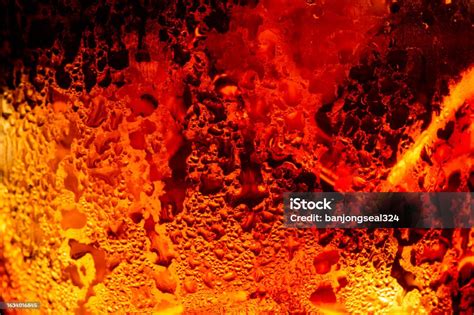 매크로 콜라 음료 배경 어두운 콜라 배경에 있는 얼음 조각의 보기를 닫습니다 유리벽에 거품과 매크로 거품이 있는 달콤한 여름 차가운 음료의 표면 거품이 일거나 수면 위로