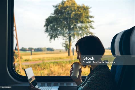 재사용 가능한 대나무 컵에 노트북과 커피를 들고 통근 열차 창문에 앉아 있는 중년 여성 기차에 대한 스톡 사진 및 기타 이미지