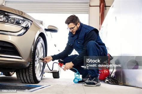 집중된 자동차 정비사가 작업장에서 타이어를 팽창시다 타이어에 대한 스톡 사진 및 기타 이미지 타이어 부풀리기 차 Istock