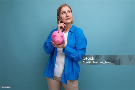 복사 공간이 있는 파란색 배경에 축적된 돈 자본을 가진 성공적인 성인 비즈니스 여성 돼지 저금통에 대한 스톡 사진 및 기타