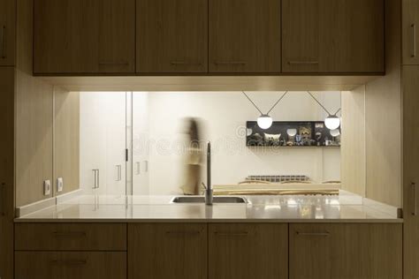 Horizontal View Of Double Modern Wood Kitchen With Person In Movement In The Back Stock Image