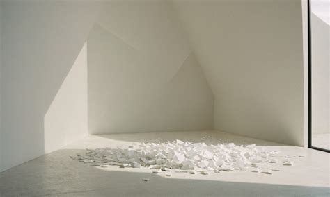 다양한 형태의 흰색 기하학적 패턴이 벽과 바닥에 흩어져 있는 모습