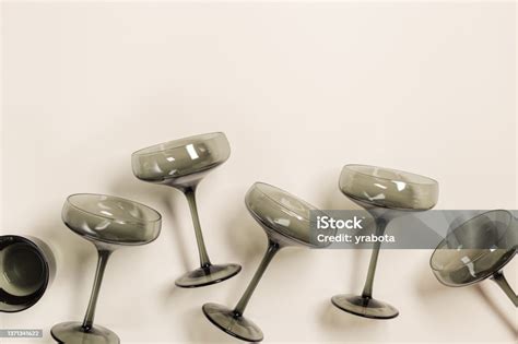 베이지 색 테이블 배경에 착색 회색 유리로 만든 샴페인 유리 최소한의 패션 음료 컨셉 트렌디 한 와인 잔 빈티지 컬러 유리 크리에이티브 플랫 레이 상단 뷰 패턴 0명에 대한