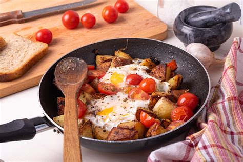 남자의 소박한 아침 식사 나무 부엌 테이블에 서 팬에 계란과 체리 토마토와 감자 튀김 0명에 대한 스톡 사진 및 기타 이미지 Istock