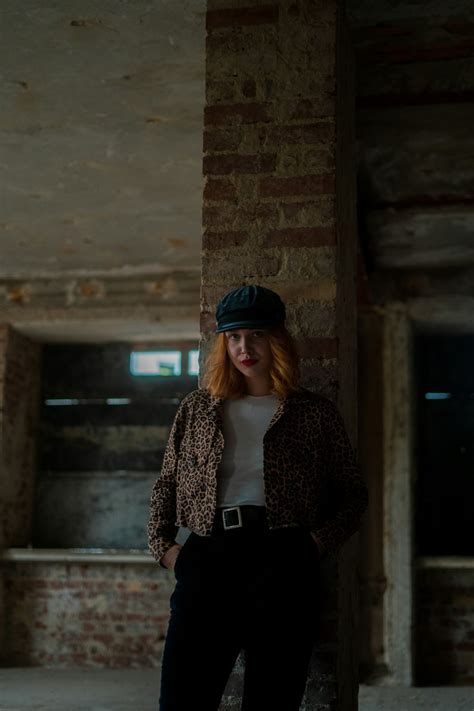 갈색과 검은색 표범 무늬 재킷 흰색 상의와 검은색 바지를 입은 여성 갈색 벽에 기대어 사진 Unsplash의 무료 녹색 이미지