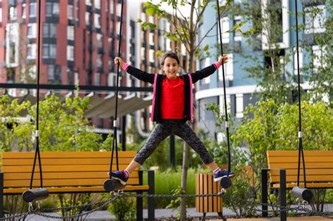 원숭이 막대에 아이입니다 학교 운동장에서 아이입니다 유치원 놀이터의 체육관 활동 센터에 매달려 있는 어린 소녀 아이들을 위한 건강한 야외 활동 어린 아이들을 위한