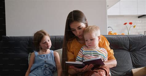 두 아이에게 책을 읽어주는 여자 사진 Unsplash의 자매 이미지