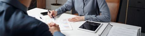 Smiling Woman Pointing At Data Report During Meeting Header Image Stock