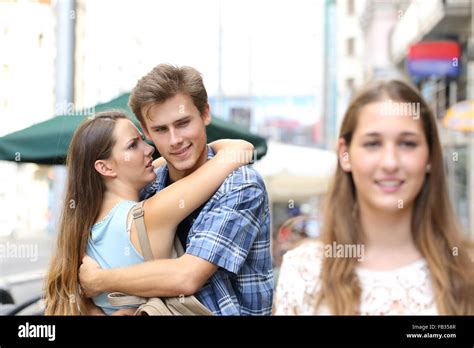 Unfaithful Man Hugging His Girlfriend While Is Looking Another One In