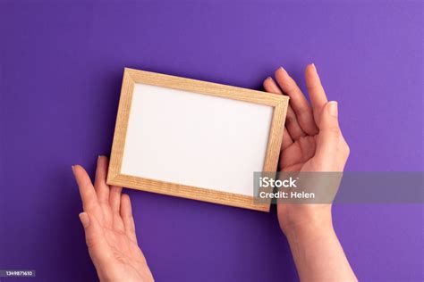 흰색 종이가 있는 나무 프레임을 모형으로 생생한 보라색 배경에 인간의 손이 있습니다 할로윈 휴일은 텍스트 템플릿 평면 누워에 대한 공간과 생일 개념을 제공합니다 액자에 대한