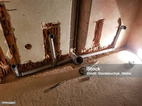 클로즈업 콘크리트 벽에 많은 새로운 하수 구리 및 플라스틱 파이프 피팅 개념 설치 배관 교체 파이프 라인 수리 전문 마스터 배관공 누설 파이프 0명에 대한 스톡 사진 및