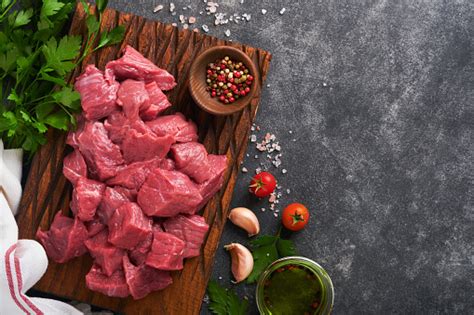 생 다진 쇠고기 고기 생 유기농 고기 쇠고기 또는 양고기 향신료 어두운 회색 콘크리트 배경에 오래된 나무 보드에 허브 굴라쉬 날것으로 조리되지 않은 고기 피가 든 고기 복사