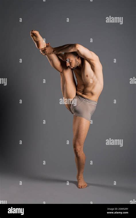 Dancer Practicing A Vertical Leg Hold Pose Showcasing Flexibility And