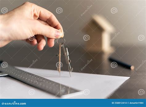 Architect Drawing With The Compass On A White Paper The Plans Of A New