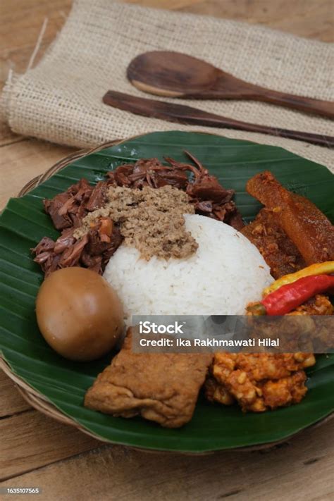 Nasi Gudeg Krecek은 가공된 어린 잭프루트 코코넛 밀크 향신료 두부 계란 및 닭고기로 만든 쌀과 구데그입니다 족자카르타 특산품 인도네시아 음식 바나나 잎과 함께