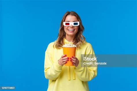 영화를 볼 수 있습니다 3d 안경에 흥분 귀여운 젊은 금발 소녀 팝콘을 들고 미소는 영화에서 영화의 시사회를 즐기는 재미 파란색 배경 위에 즐겁게 서 교육에 대한 스톡 사진