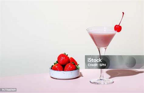 보드카 리큐어 크림 시럽 딸기 및 얼음을 칵테일 체리와 함께 유리에 넣은 현상금 마티니 여름 알코올 칵테일 음료 베이지 핑크