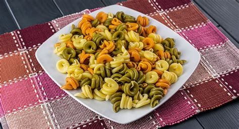 토마토 소스와 갈은 치즈 식탁보와 회색 나무 테이블에 마무리 할 준비가 다채로운 야채와 파스타 요리 0명에 대한 스톡 사진 및