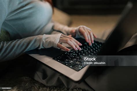 알아볼 수 없는 젊은 여성이 원격으로 노트북으로 작업하고 저녁에 침대에 앉아 키보드를 타이핑하는 클로즈업 사진 성공한 여성 프리랜서가 새로운 프로젝트에 대해 논의하고