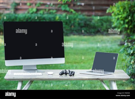 Selective Focus Of Joystick Computer And Laptop With Blank Screens On Table Outdoors Stock