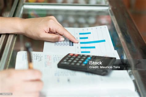 그녀의 비즈니스 통계 그래프를 가리키는 여자의 손 친환경 골판지 펜과 작은 검은 색 계산기로 대형 노트북에 글을 쓰고 있습니다 통계학자의 개념 그래프 종이에 대한 스톡 사진