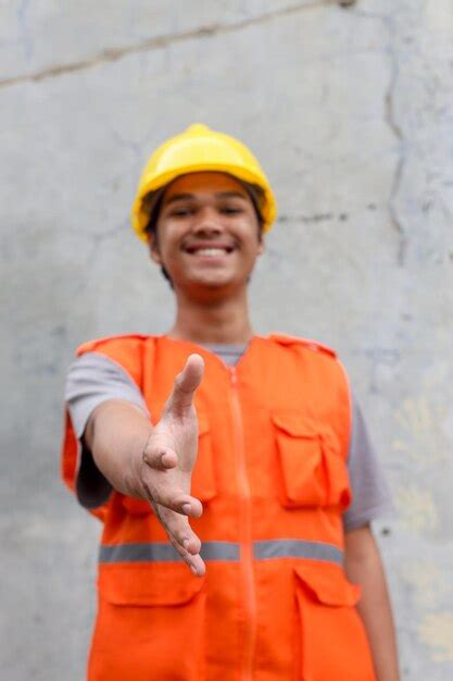 Premium Photo Young Asian Worker Wearing Orange Vest And Safety Helmet Smiling Friendly