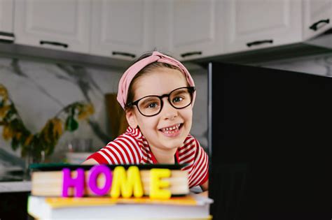 원격 학습 온라인 교육 집에서 디지털 태블릿 노트북 노트북을 가지고 공부하고 학교 숙제를하는 여학생 소녀 교과서가 있는 테이블에 앉아 있습니다 6 7 살에 대한 스톡 사진