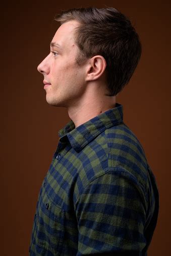 배경색에 대 한 녹색 체크 무늬 셔츠를 입고 젊은 잘생긴 사업가의 스튜디오 샷 20 29세에 대한 스톡 사진 및 기타 이미지 20 29세 25 29세 갈색 배경