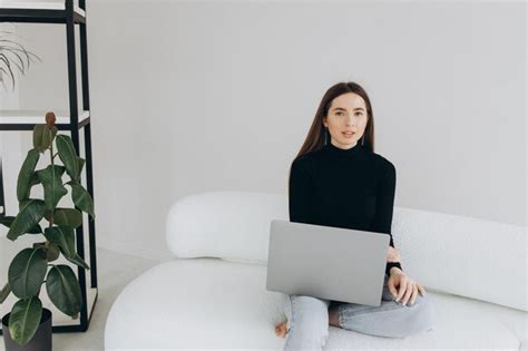 Hermosa Joven Usando La Computadora Portátil En Casa Foto Premium