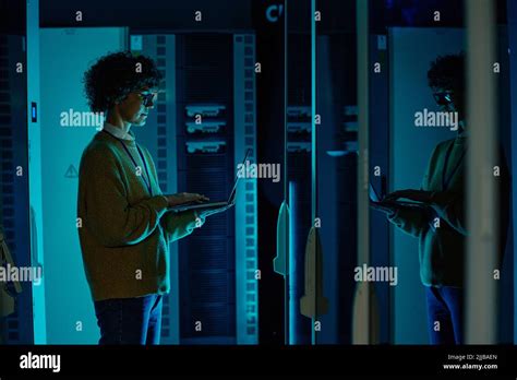 It Engineer Standing Before Working Server Rack Doing Routine Maintenance Check And Diagnostics