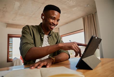 현대 가정에서 원격 작업하는 동안 전자 태블릿에 젊은 성인 흑인 남성 스크롤 남성에 대한 스톡 사진 및 기타 이미지 남성 남아프리카공화국 남자 Istock