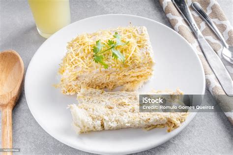 전형적인 브라질 요리 인 차가운 짭짤한 치킨 파이 조각을 자릅니다 흰색 접시 회색 나무 배경 나무 숟가락 칼 붙이 및 캐슈 주스 옆에 있습니다 갈색에 대한 스톡 사진 및